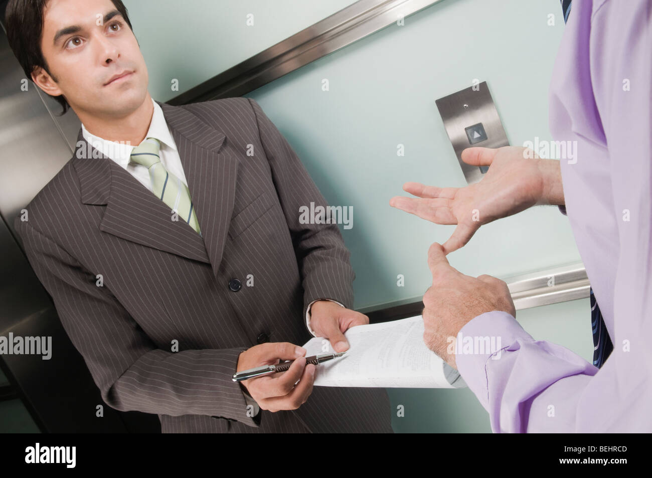 Businessmen discussing in an elevator Stock Photo - Alamy