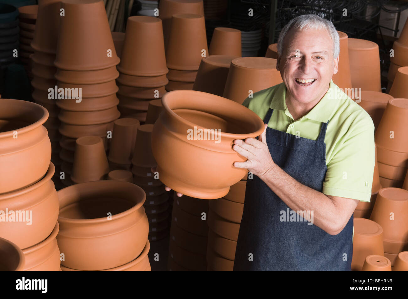 Man showing flower pot in a garden center Stock Photo - Alamy