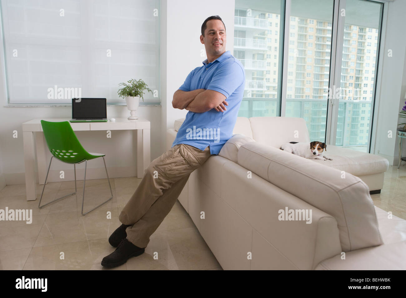 Man leaning against a sofa Stock Photo - Alamy