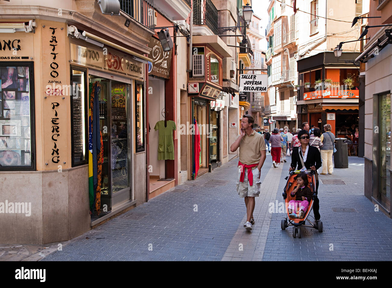 People in shopping street outside tattoo piercing sign Palma Mallorca ...