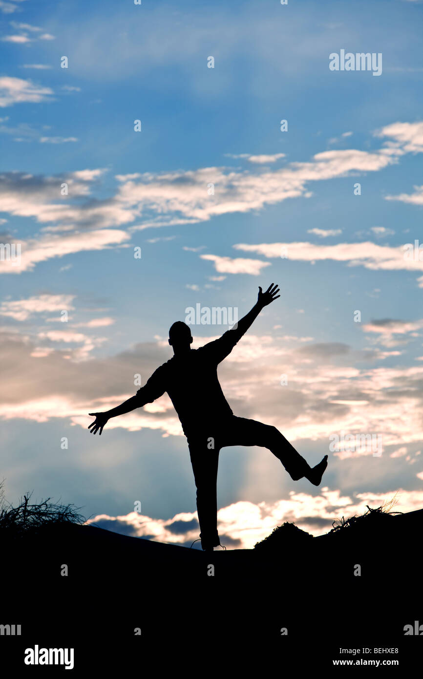 Person balancing on one leg outdoors silhouetted against the sky Stock ...