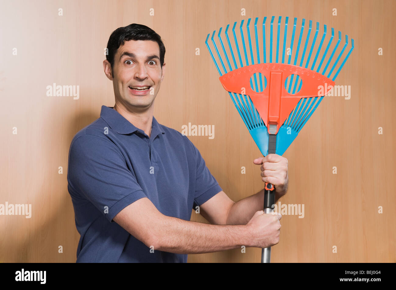 Portrait of a man holding a rake Stock Photo - Alamy
