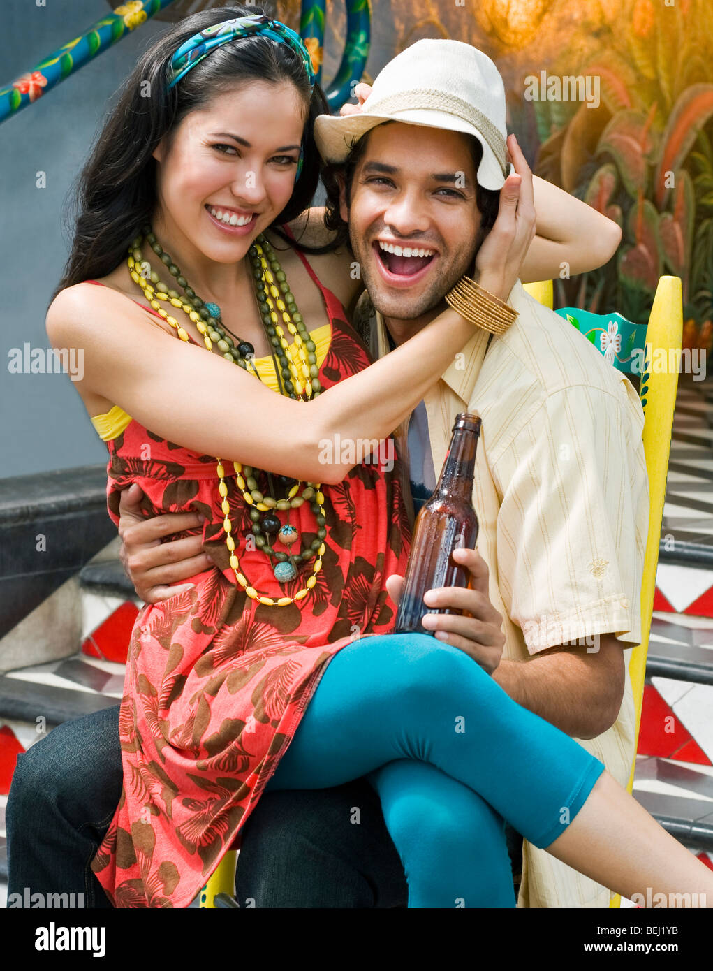 Portrait of a young woman sitting on the lap of a young man Stock Photo ...