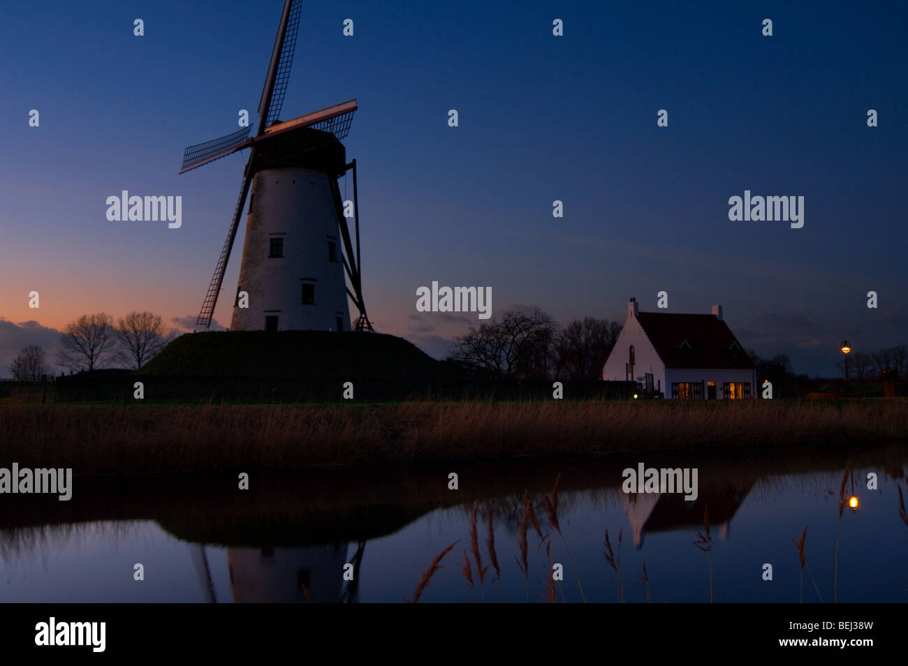 The traditional windmill Schellemolen at sunset along the Damme Canal ...