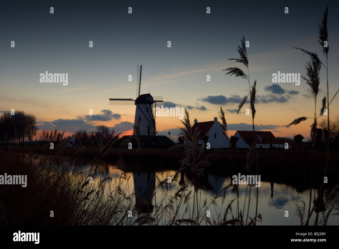 The traditional windmill Schellemolen at sunset along the Damme Canal ...