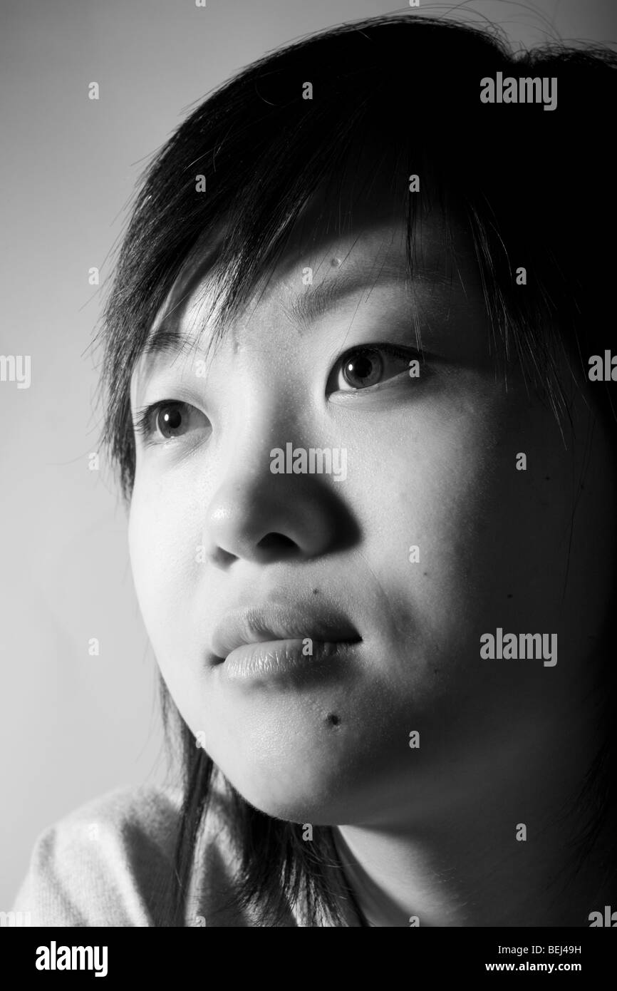 A wistful look in the eye of this young Asian woman Stock Photo - Alamy