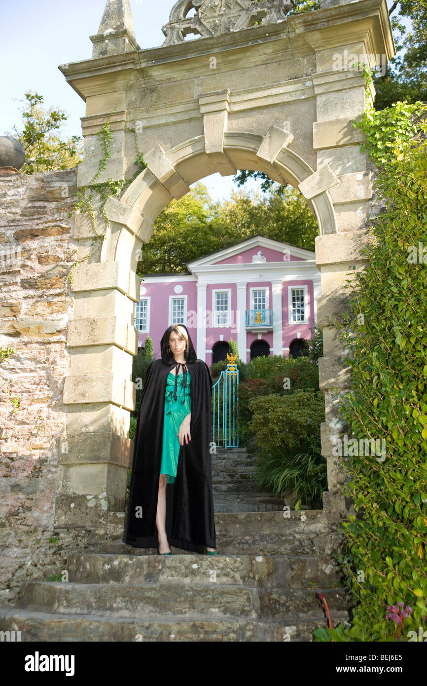 Pretty young woman in a green dress and velvet cloak in the gardens at ...