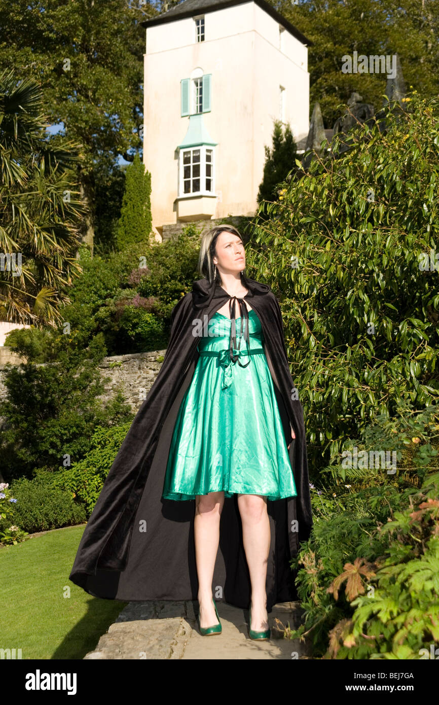 Pretty young woman in a green dress and velvet cloak in the gardens at ...