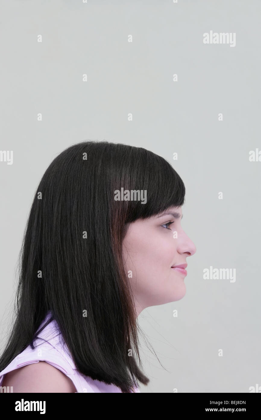 Side profile of a young woman smirking Stock Photo - Alamy