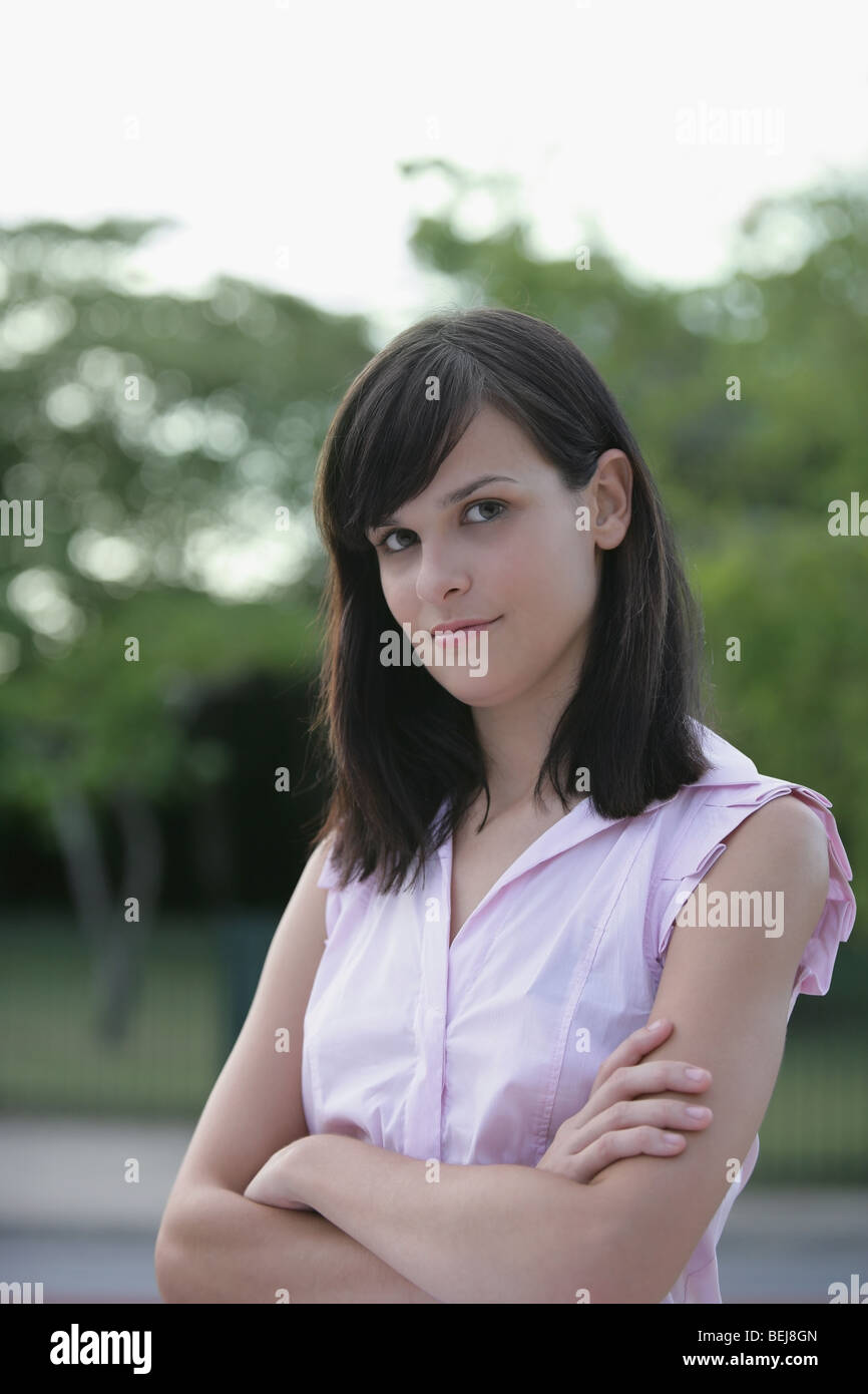 Portrait of a young woman standing with her arms crossed Stock Photo ...