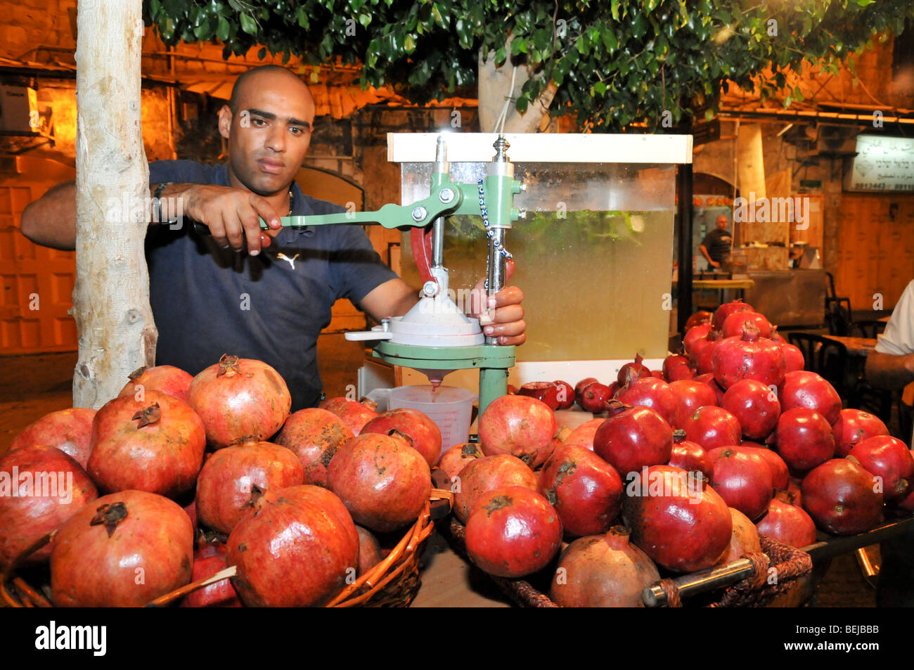 Israel, Acre, Man squeezes fresh pomegranate juice at a stall in the ...