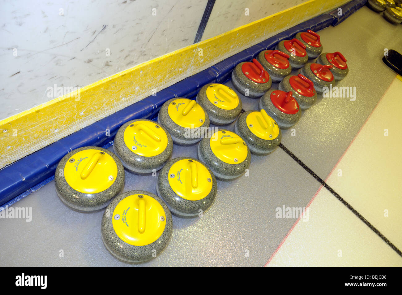 Yellow and Red Curling stones on the ice Stock Photo - Alamy