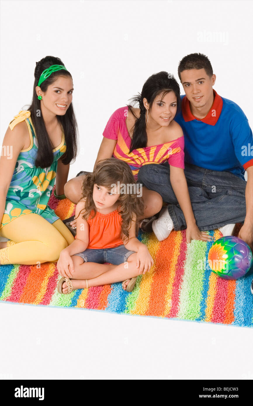 High angle view of four people sitting together on a rug Stock Photo ...