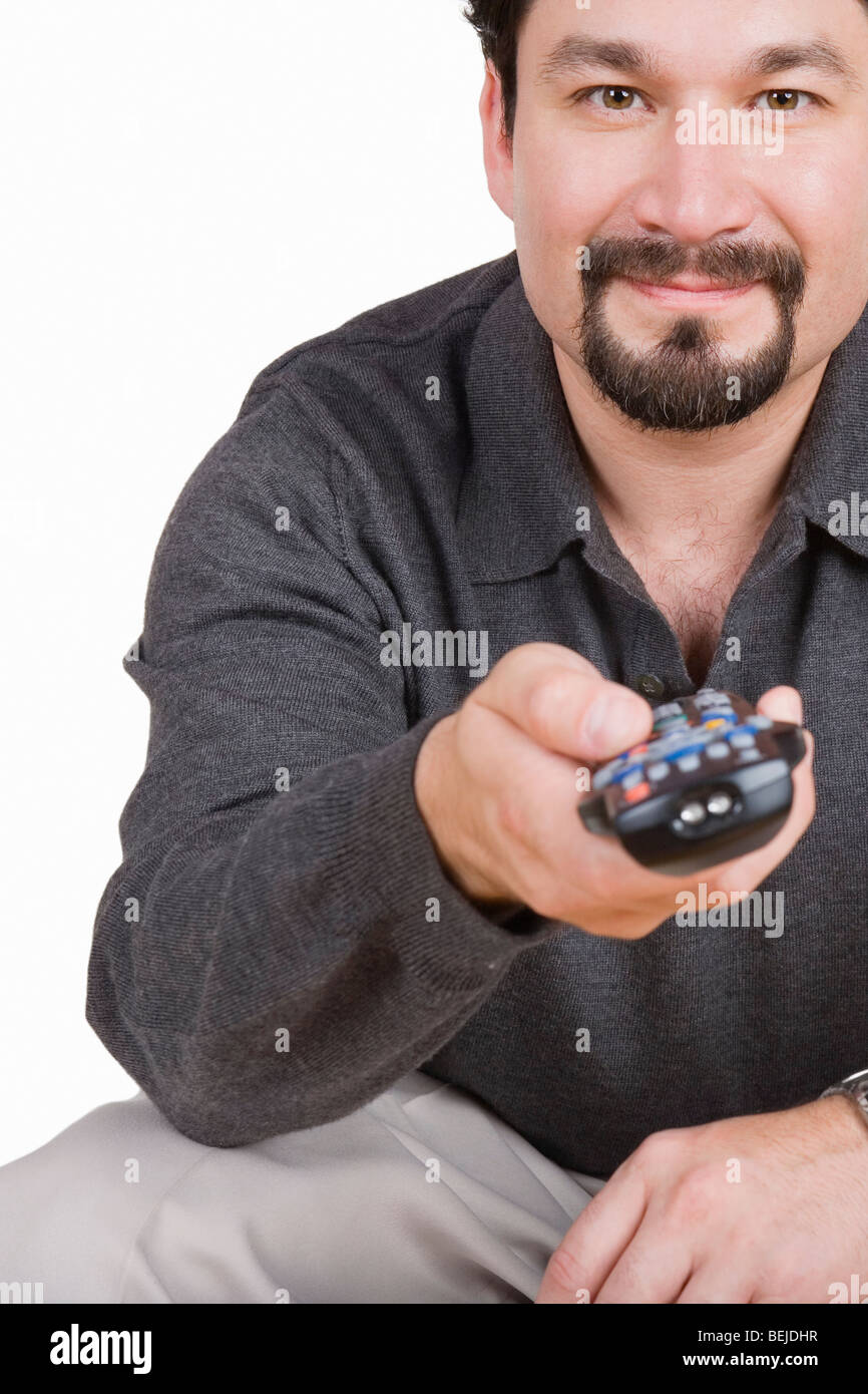 Portrait of a mid adult man holding a remote control and smirking Stock ...