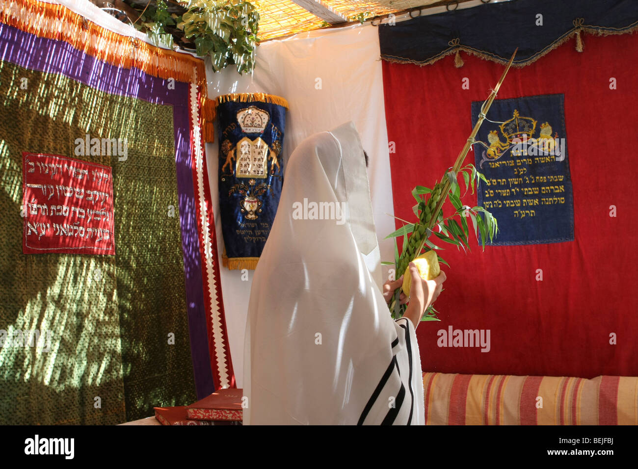 Interior of a Sukkah during Sukkoth A man wrapped in a tallith holding ...