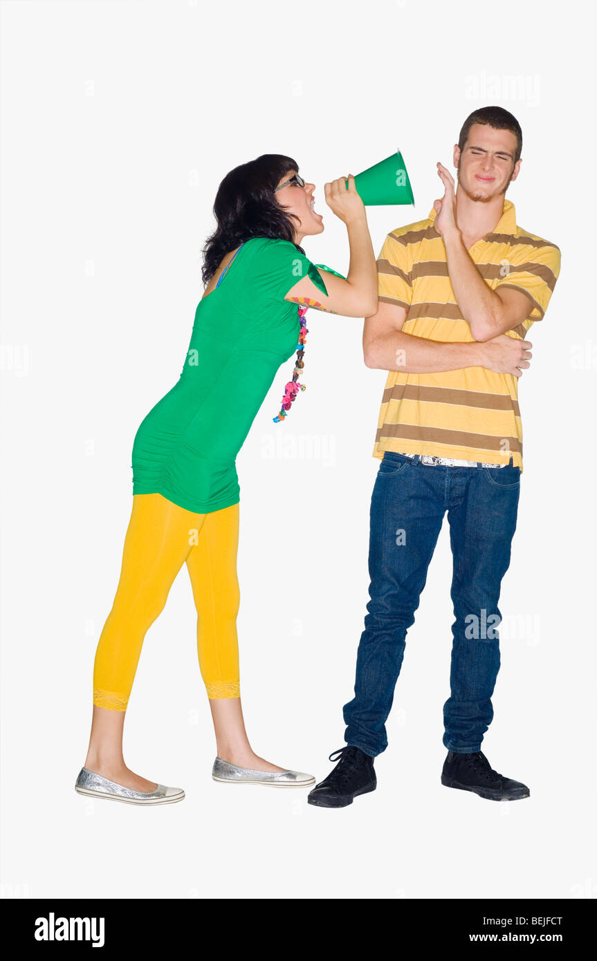 Young woman shouting with a megaphone into a young man's ear Stock ...