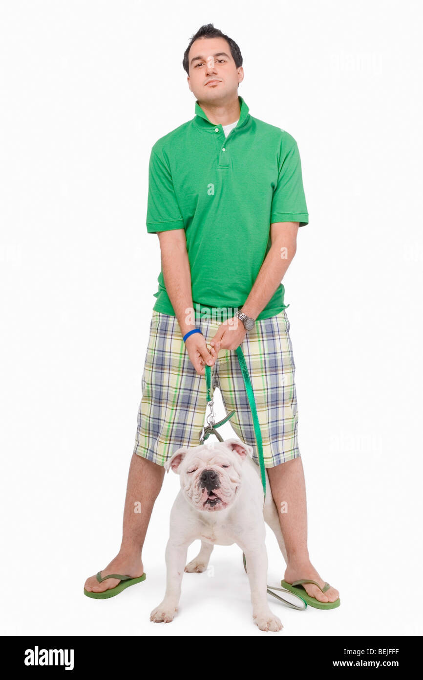 Portrait of a young man standing with a dog Stock Photo - Alamy