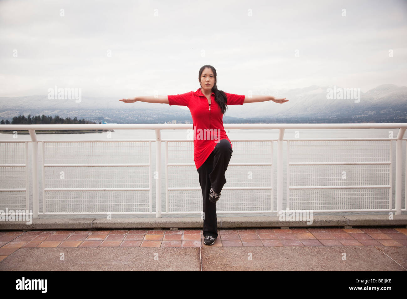 A young Asian woman does the Vrksasana Tree Pose yoga pose at Canada ...