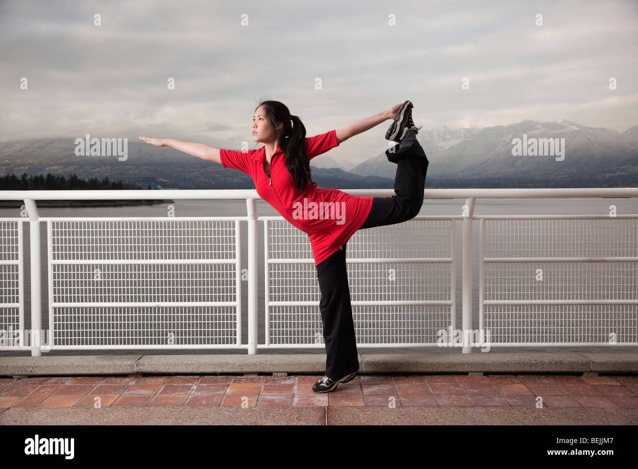 A young Asian woman does the Natarajasana Lord of the Dance yoga pose ...