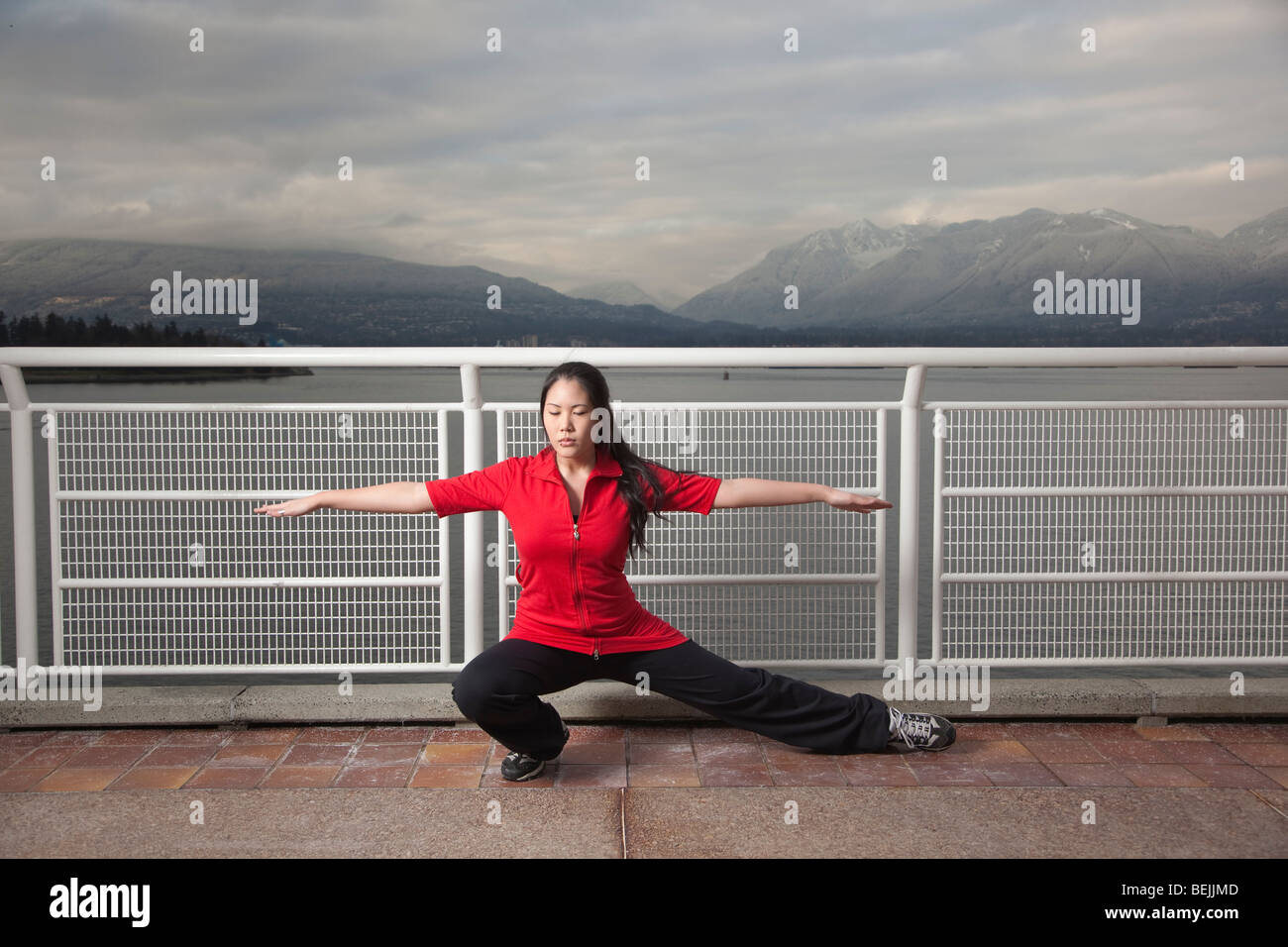 A young Asian woman doing yoga at Canada Place, Vancouver, British ...