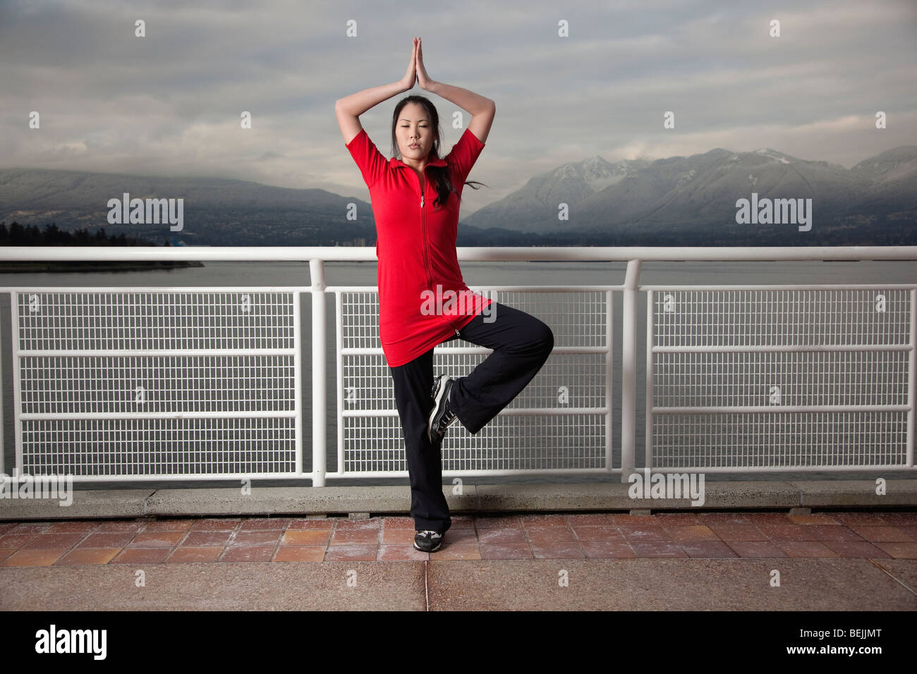A young Asian woman does the Vrksasana Tree Pose yoga pose at Canada ...