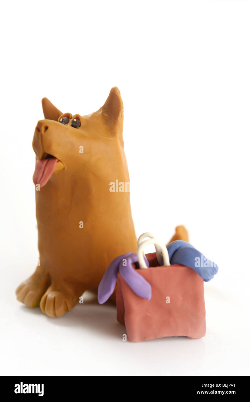 orange plasticine dog goes shopping with bag, isolated on white Stock ...