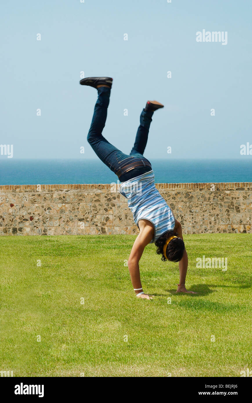 Rear view of a man doing a handstand in a park Stock Photo - Alamy