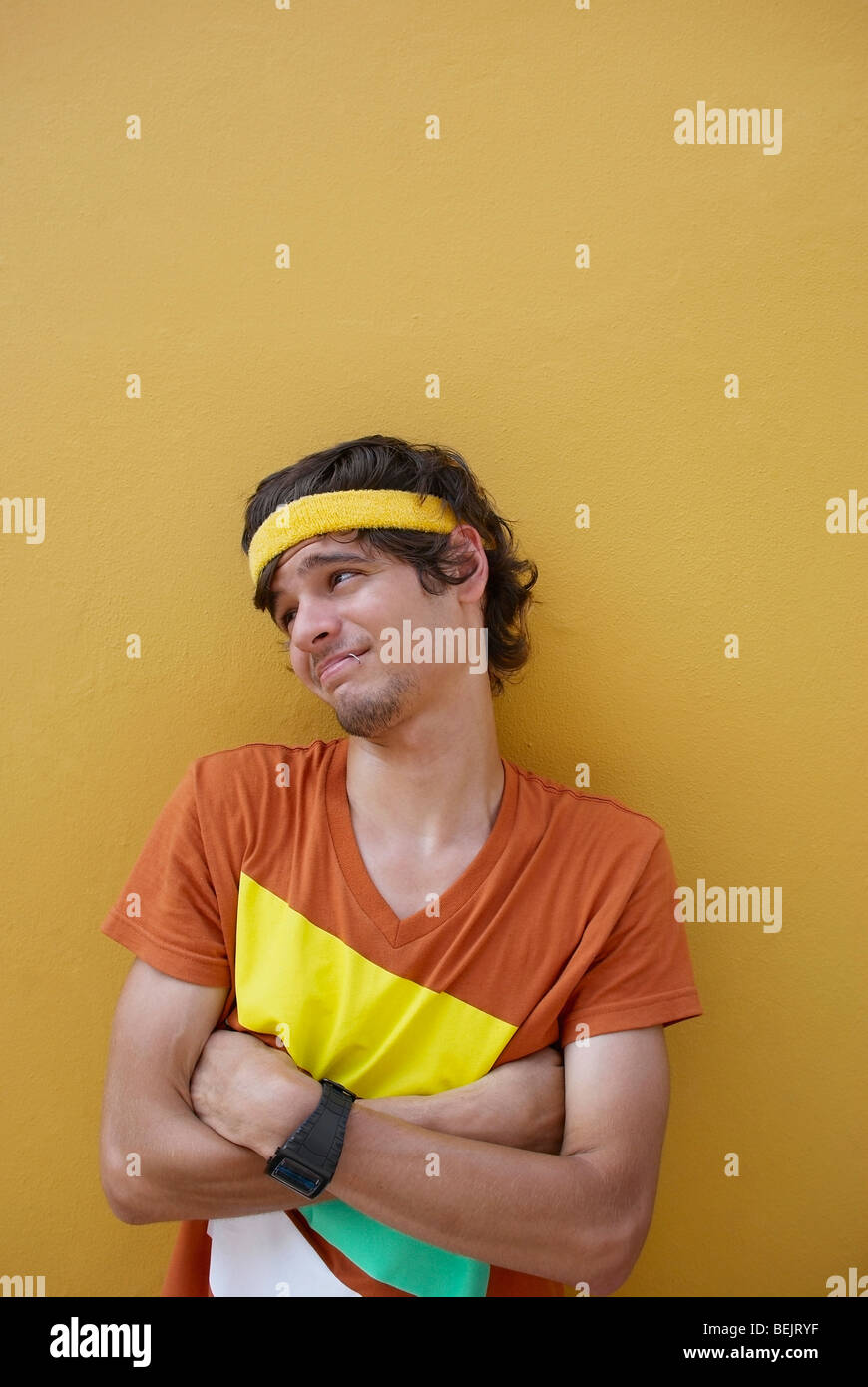 Young man standing with his arms crossed and making a face Stock Photo ...