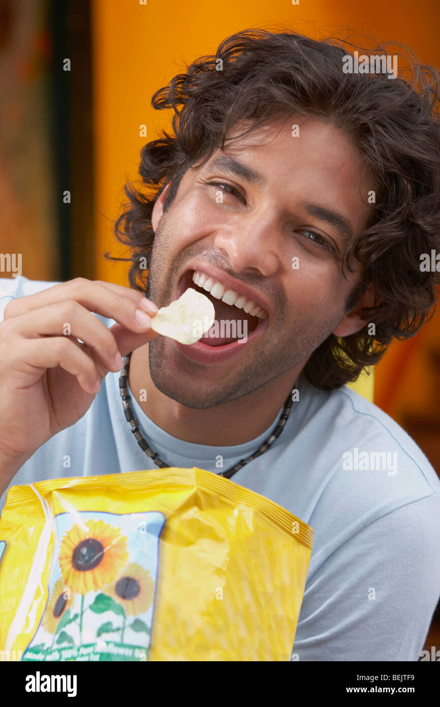 Young man eating potato chip hi-res stock photography and images - Alamy