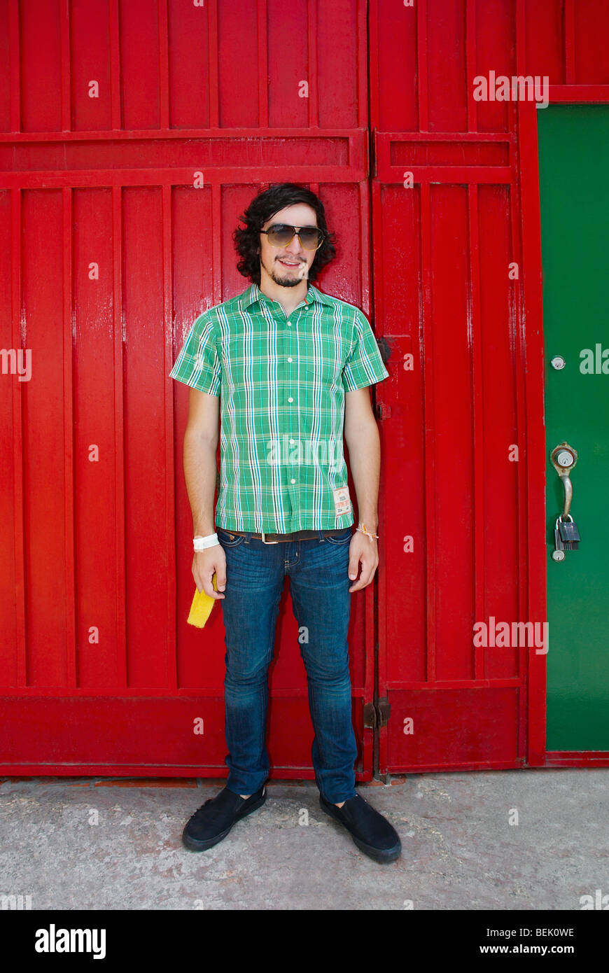Young man standing in front of a gate Stock Photo - Alamy