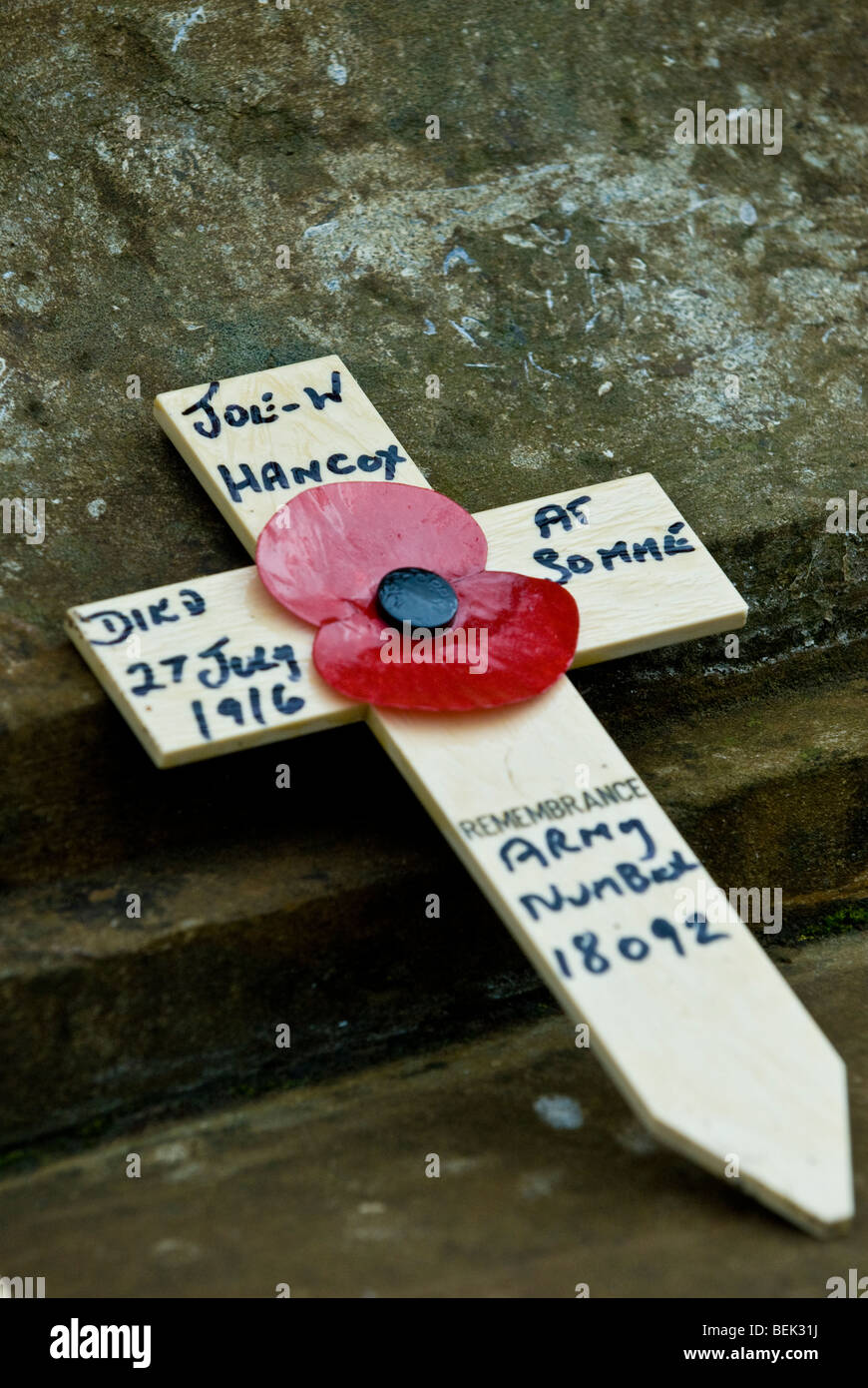 A single wooden cross laid at the base of a memorial on armistice day ...