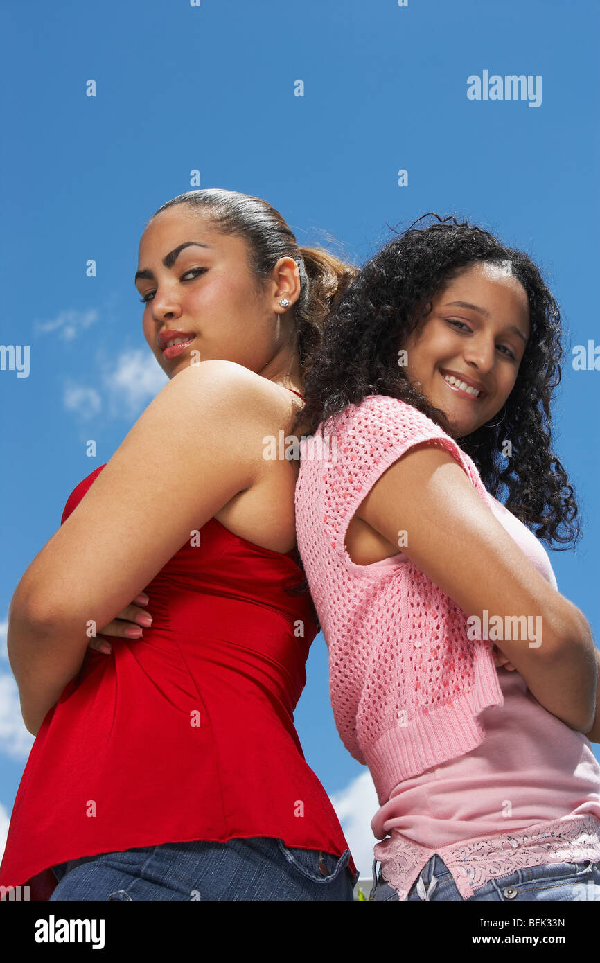 Side profile of two teenage girls standing back to back Stock Photo - Alamy