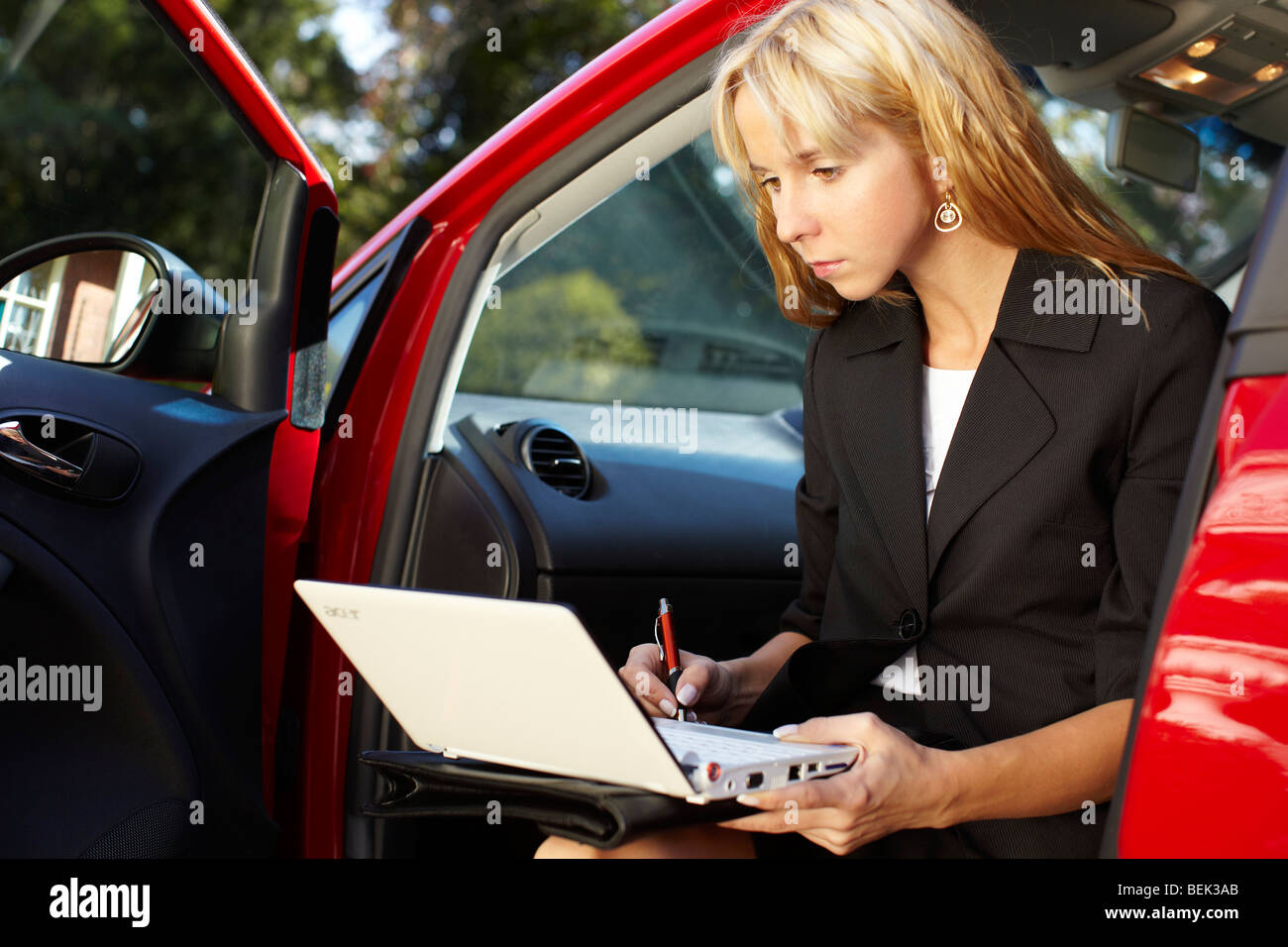 Woman sat in car with laptop Stock Photo - Alamy