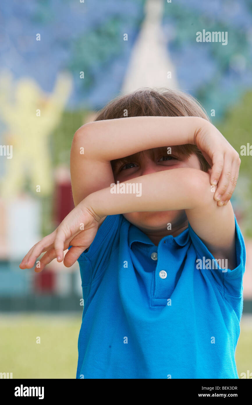 Portrait of a boy hiding his face with his arms Stock Photo - Alamy