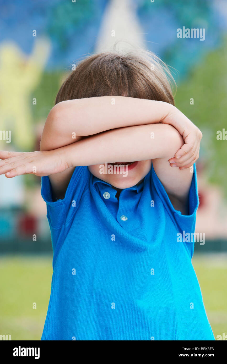 Close-up of a boy hiding his face with his arms and crying Stock Photo ...