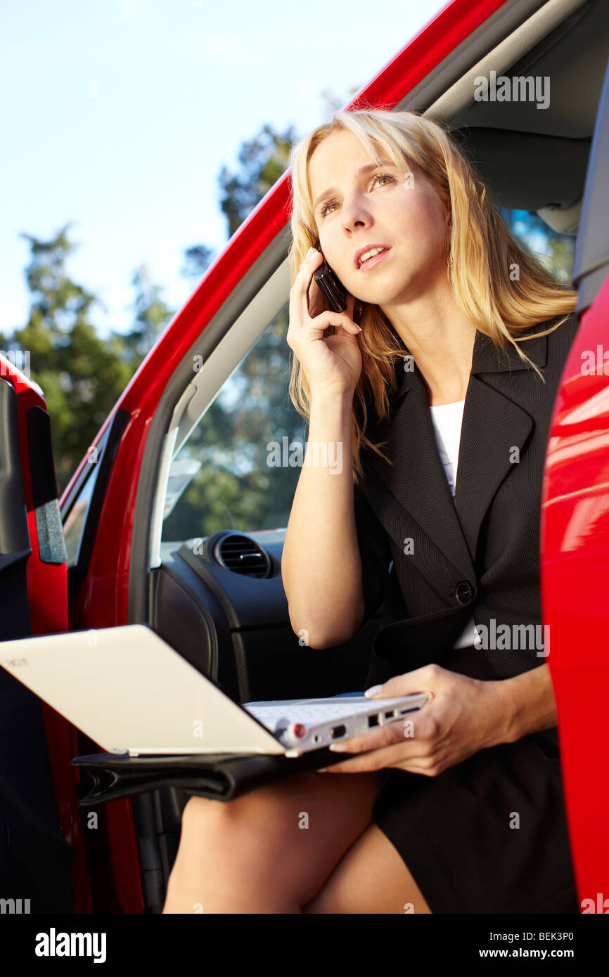 Woman sat in car with laptop Stock Photo - Alamy