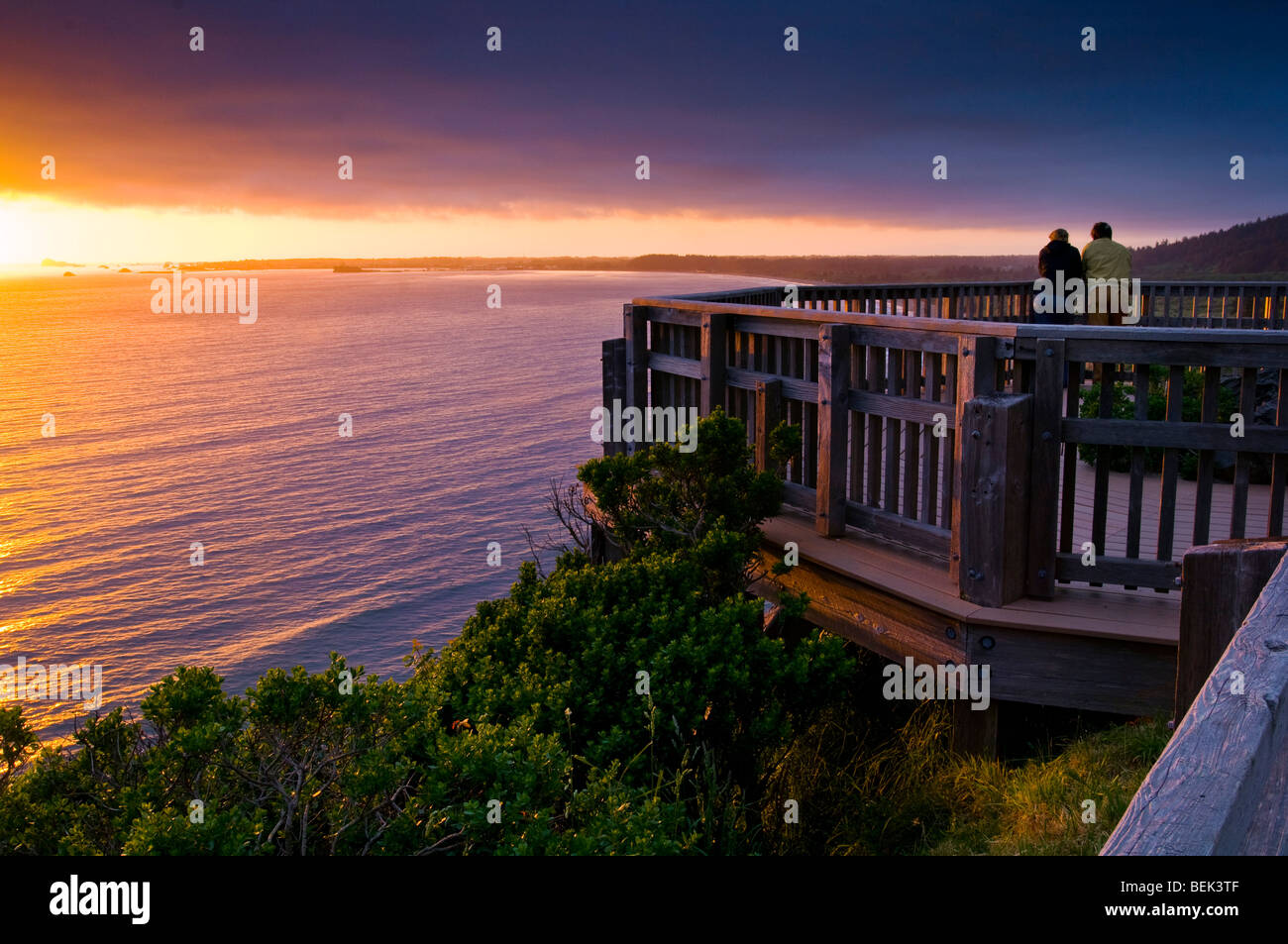 Couple watching the sunset over the ocean from Enderts Beach Overlook ...