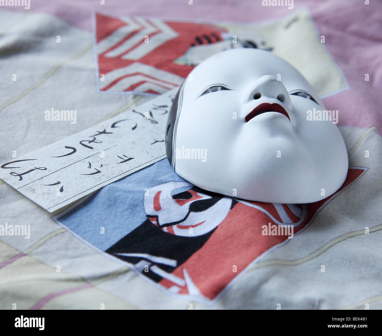 female noh mask with Japanese characters on fabric with a Japanese ...