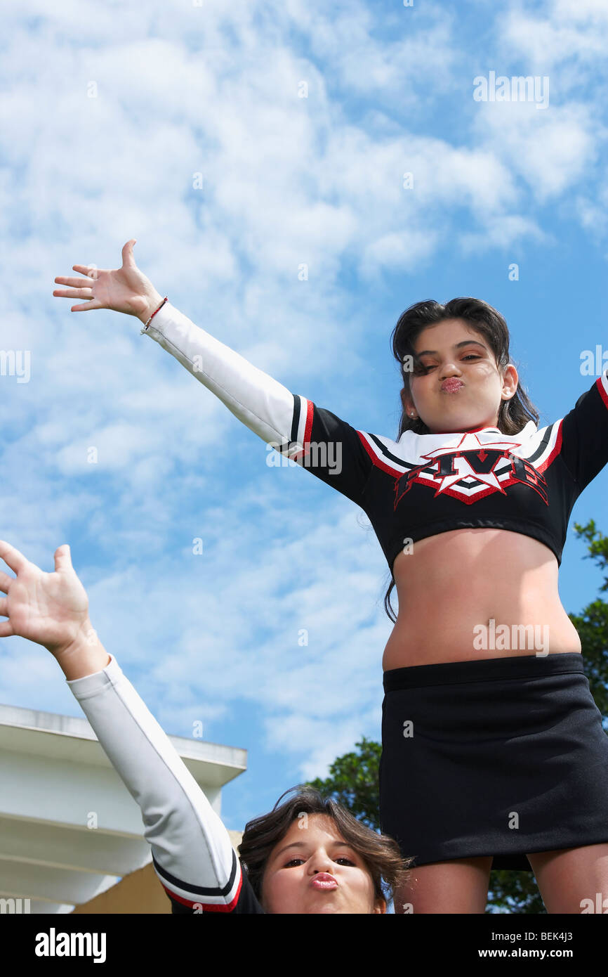 Low angle view of two cheerleaders balancing Stock Photo - Alamy
