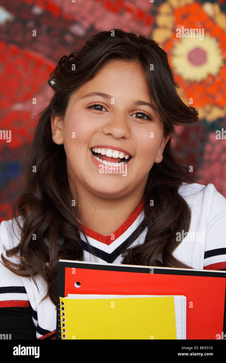 Portrait of a girl holding books and laughing Stock Photo - Alamy
