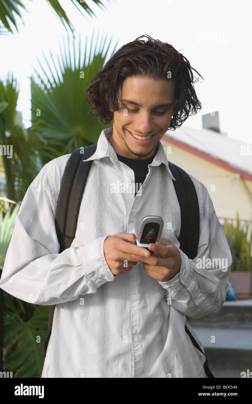 College student using a mobile phone and smiling Stock Photo - Alamy