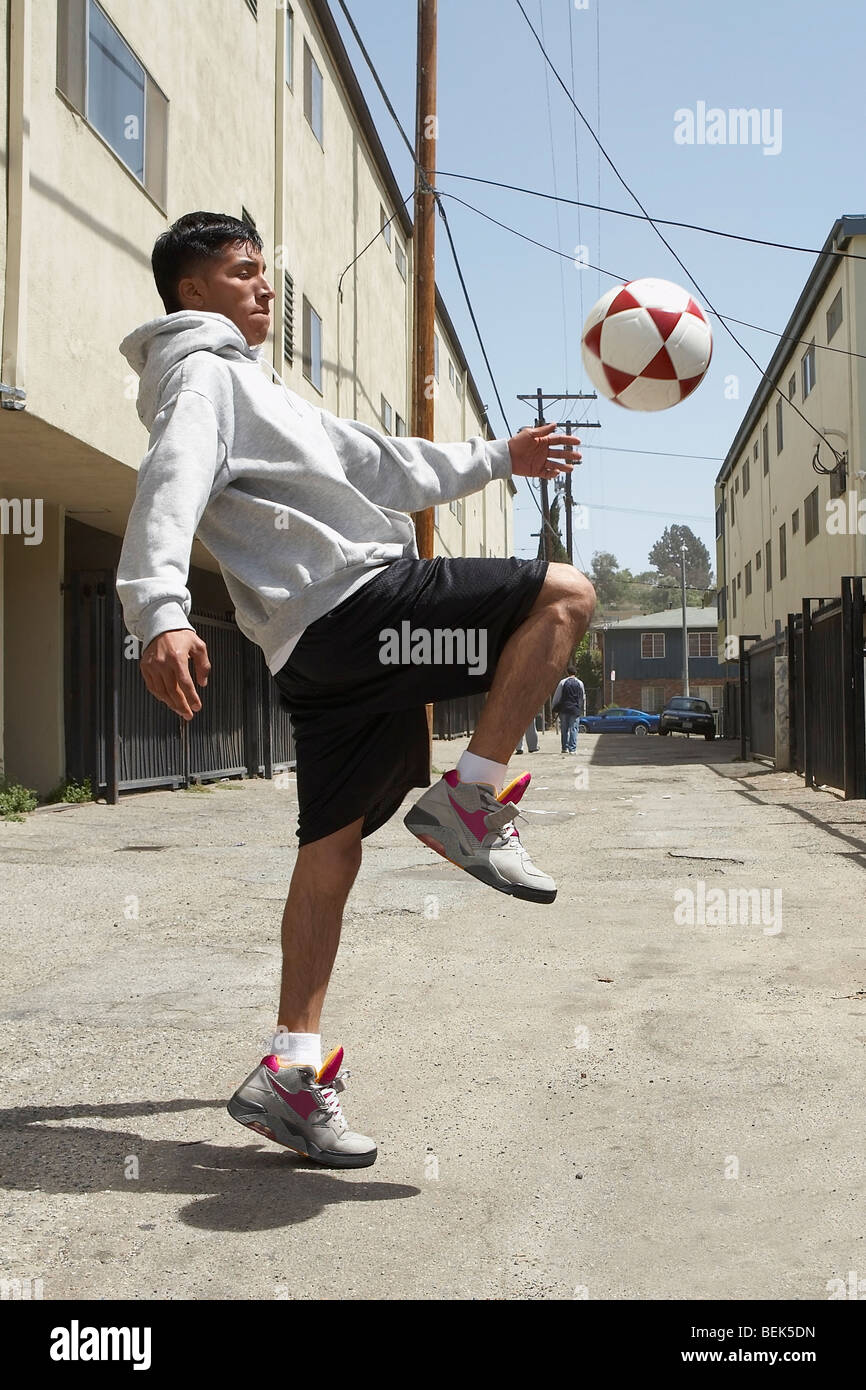 Side profile of a young man playing with a soccer ball Stock Photo - Alamy