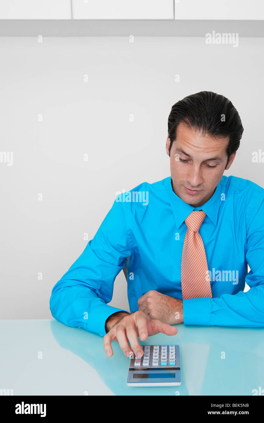 Businessman using a calculator in an office Stock Photo - Alamy