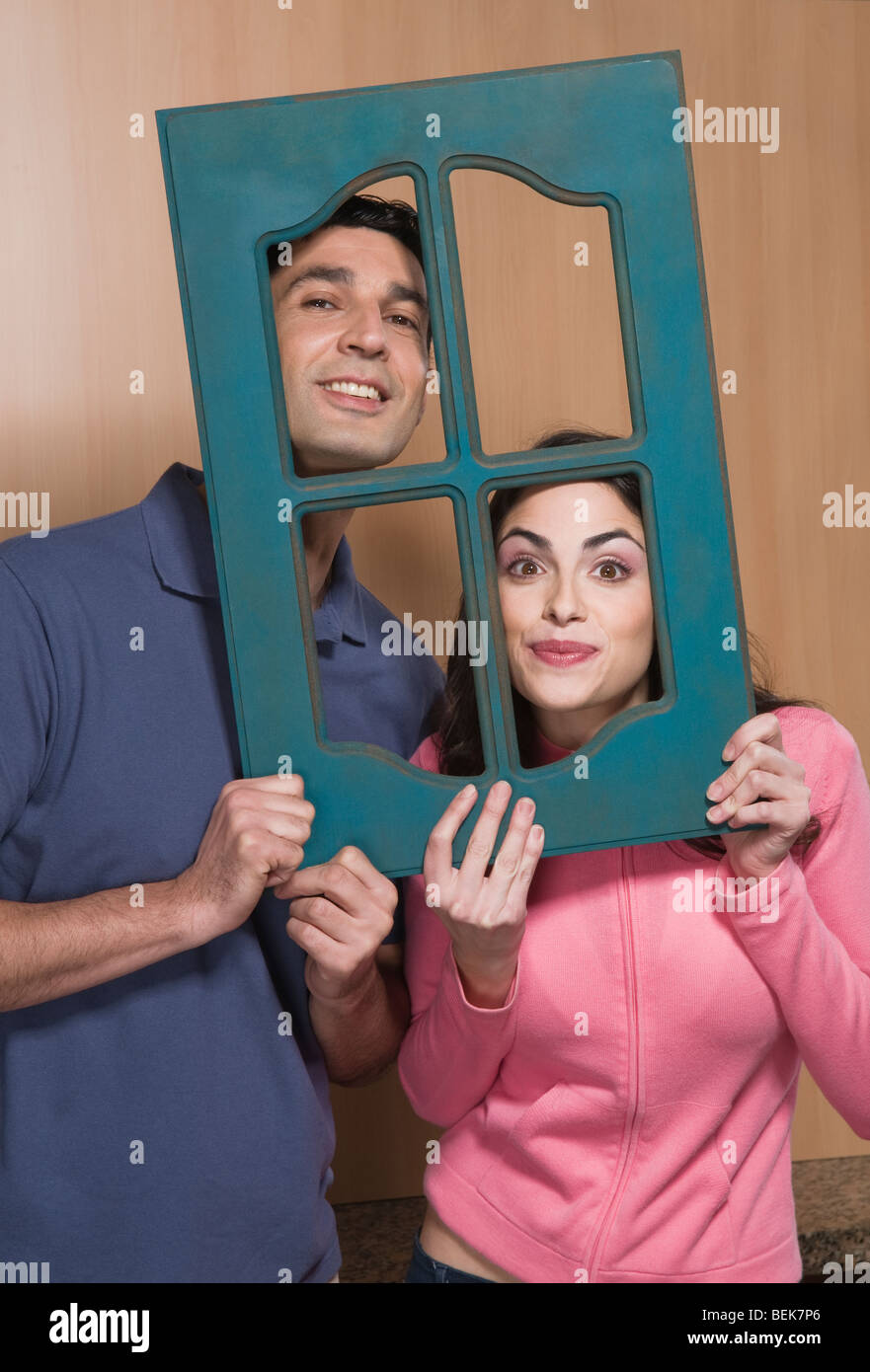 Portrait of a couple holding a window frame Stock Photo - Alamy