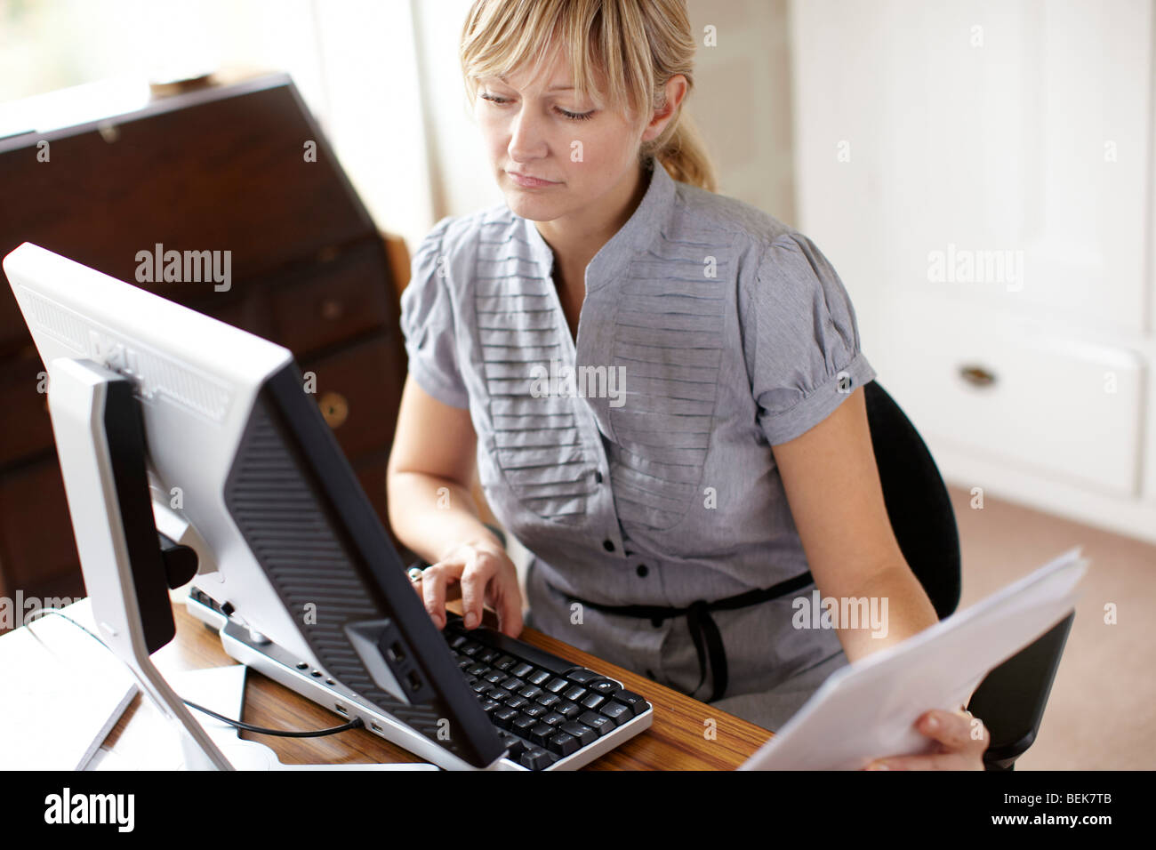 Woman sat at desk Stock Photo - Alamy