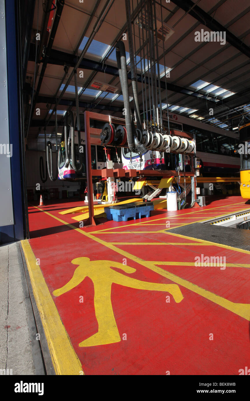 Yellow painted safety warning sign on walkway in busy maintenance ...