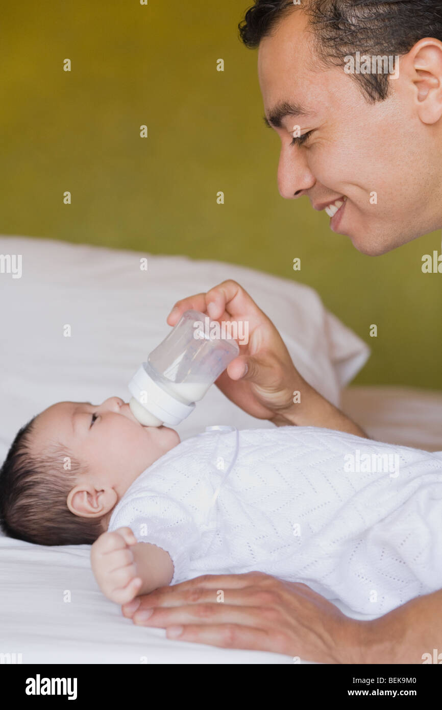 Man feeding his son with a baby bottle Stock Photo - Alamy