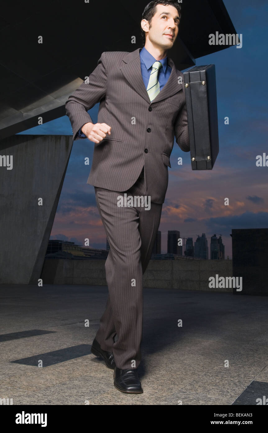 Businessman running with a briefcase Stock Photo - Alamy