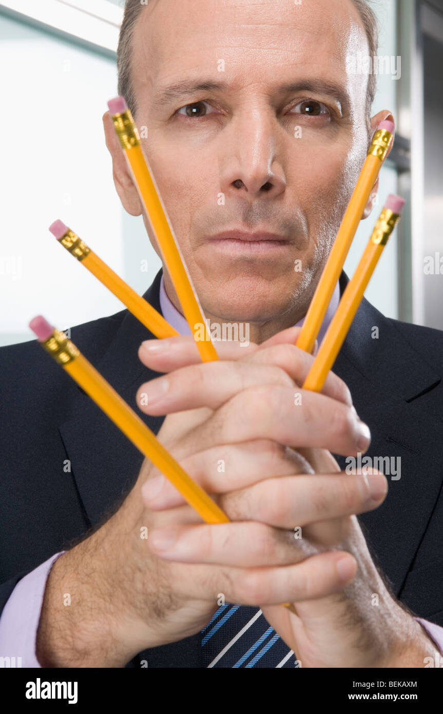 Portrait of a businessman holding pencils and thinking Stock Photo - Alamy