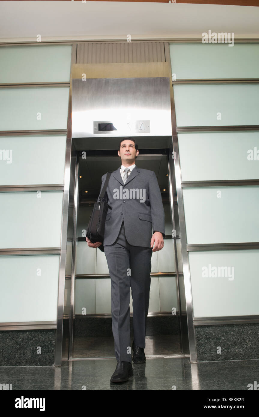 Businessman stepping out of an elevator Stock Photo - Alamy